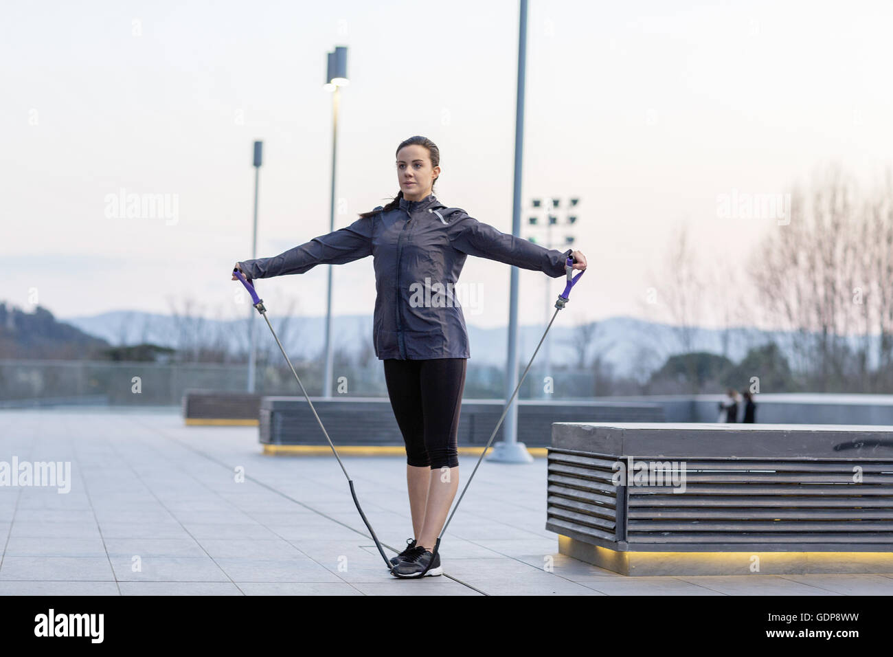 Young woman exercising outdoors, using stretching rope Stock Photo - Alamy