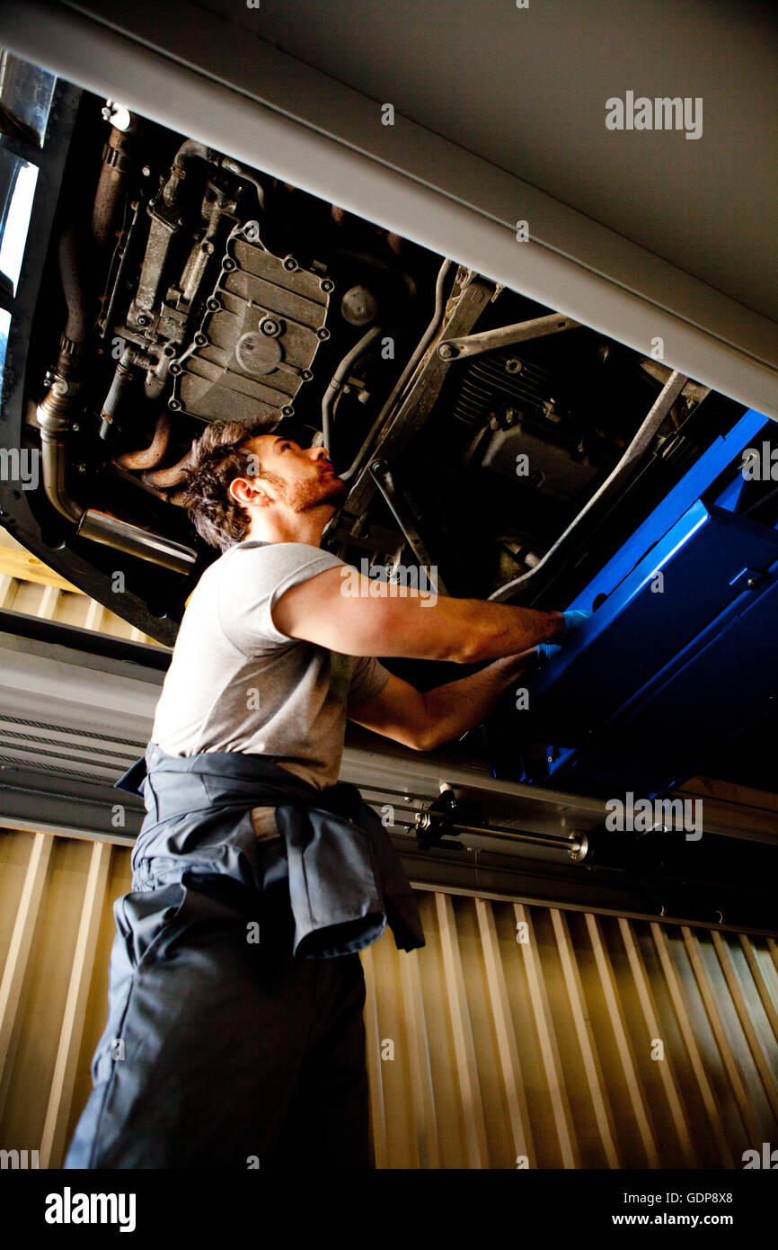 Male mechanic checking engine of car from underneath the vehicle Stock ...