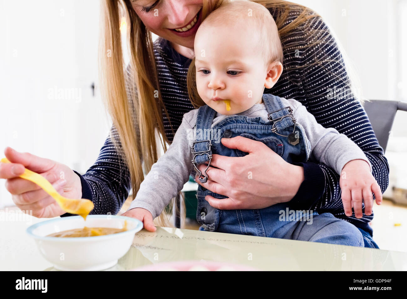 Woman feeding baby daughter at table Stock Photo - Alamy