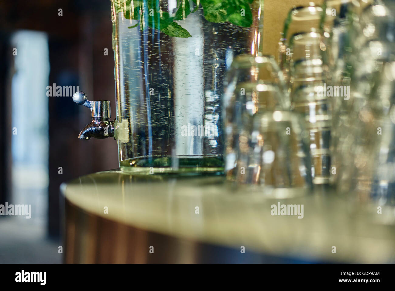 Stack of drinking glasses and water cooler on counter in coffee shop ...
