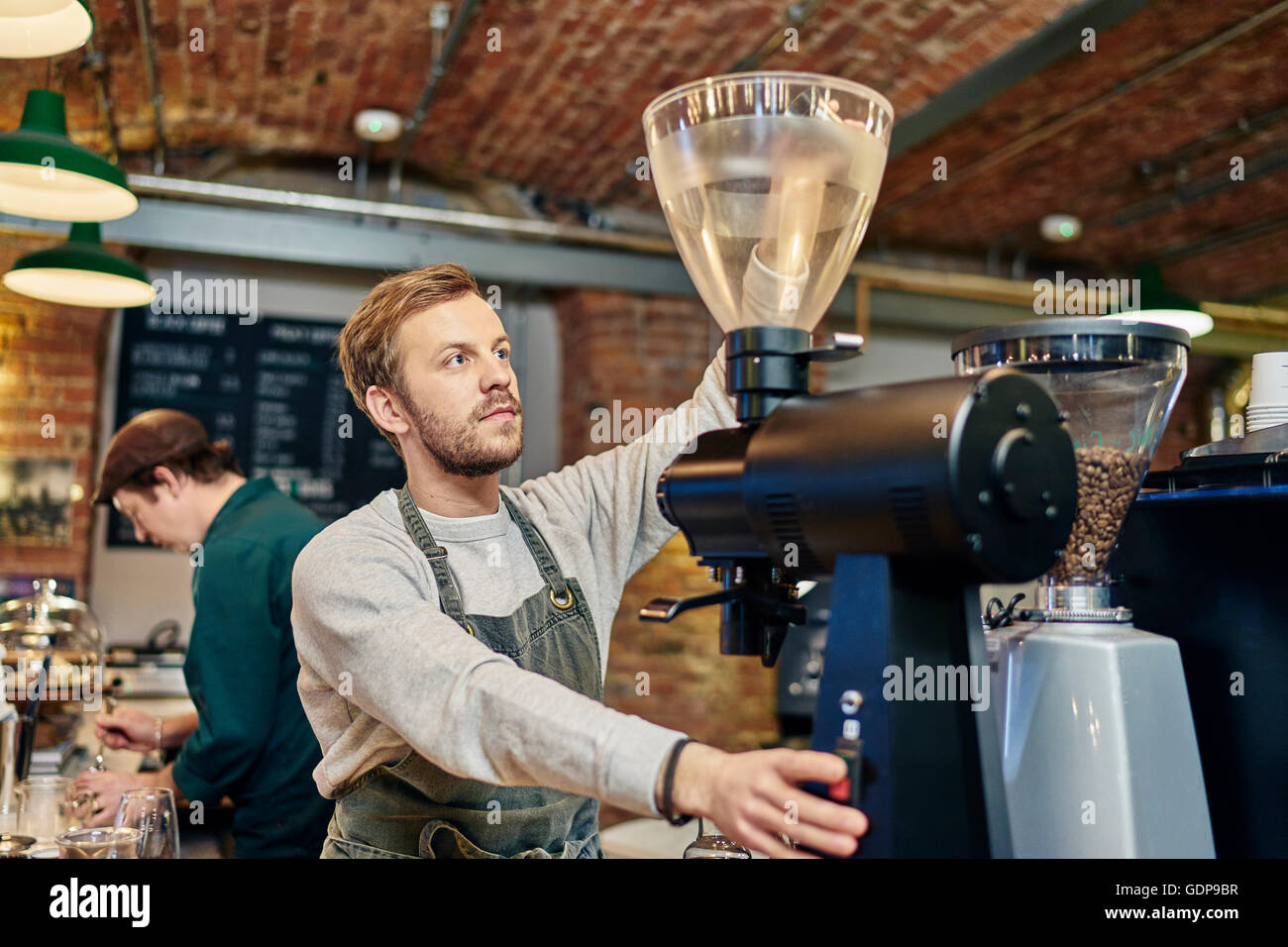 Male barista using coffee machine at coffee shop kitchen counter Stock ...