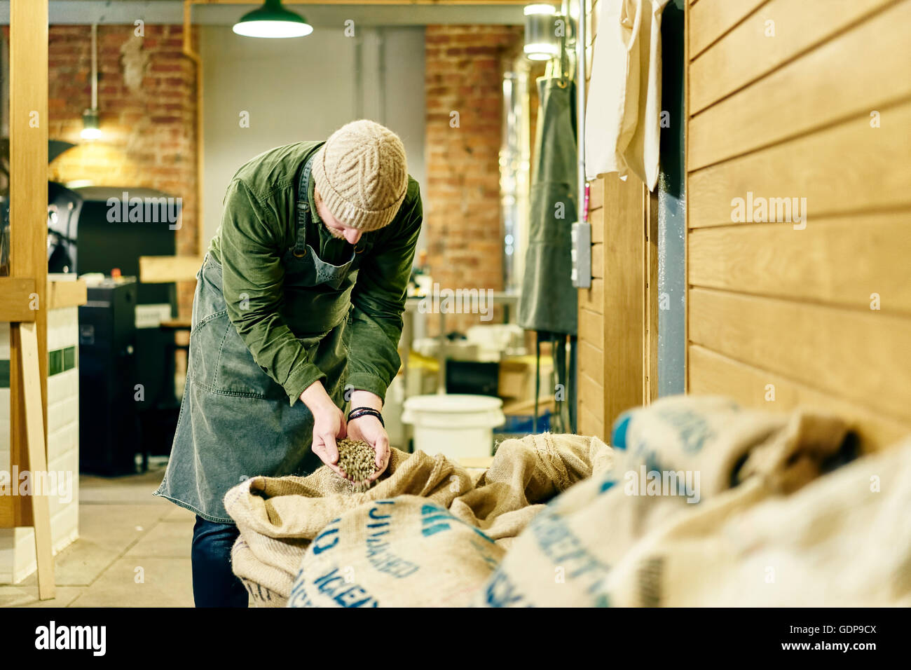 Male coffee shop owner checking raw coffee beans in store room Stock ...