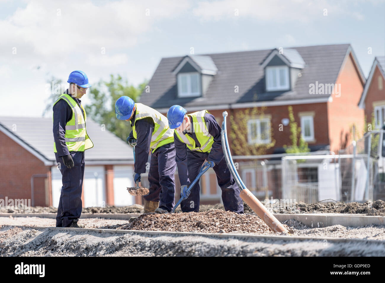 Apprentice builders digging on building site Stock Photo - Alamy