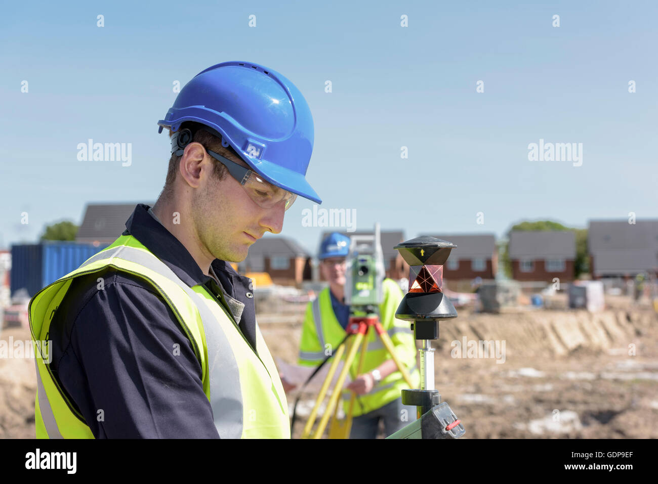 Apprentice builders using theodolite on building site Stock Photo - Alamy