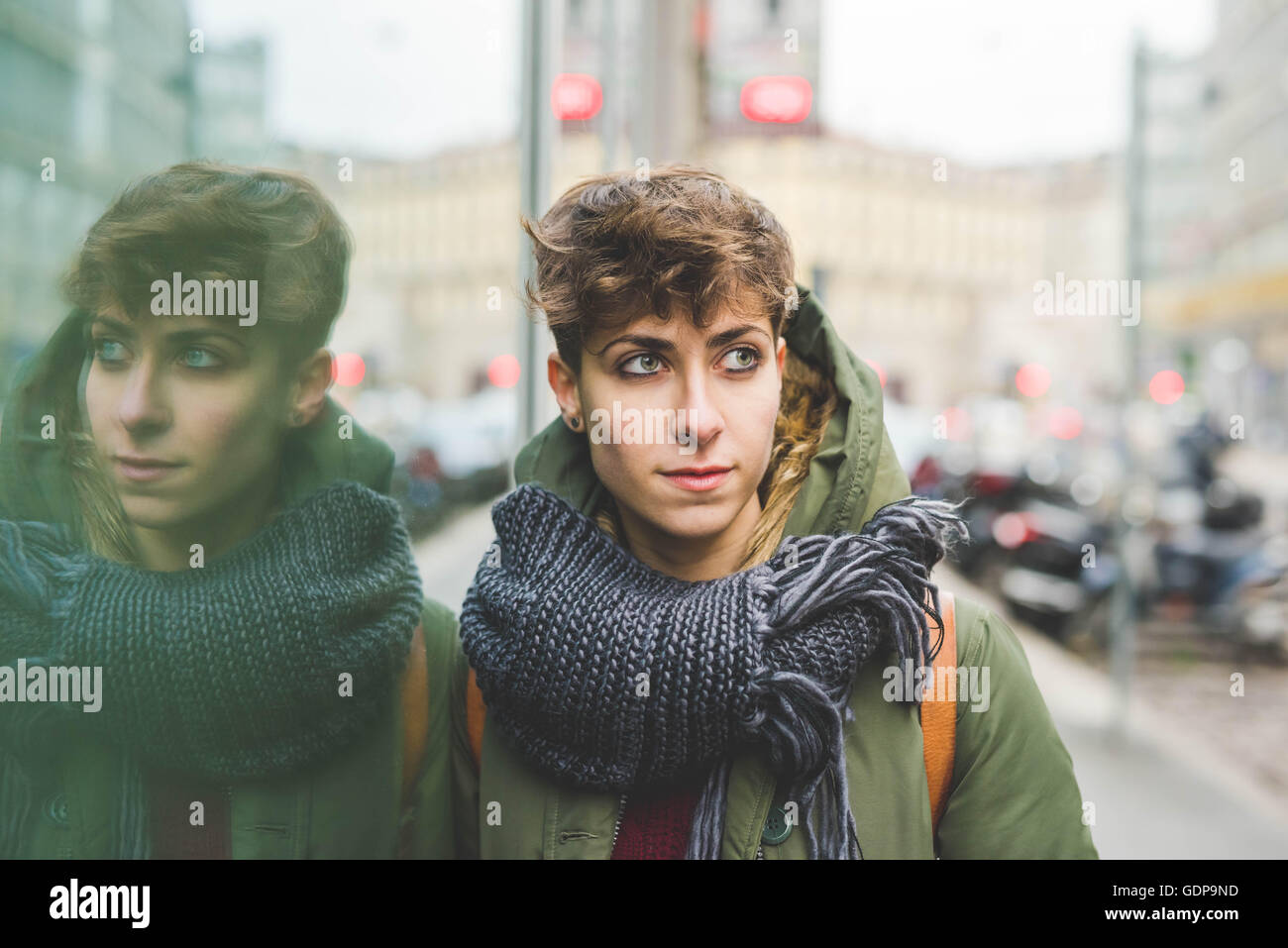 Portrait of young woman leaning against window, outdoors Stock Photo ...