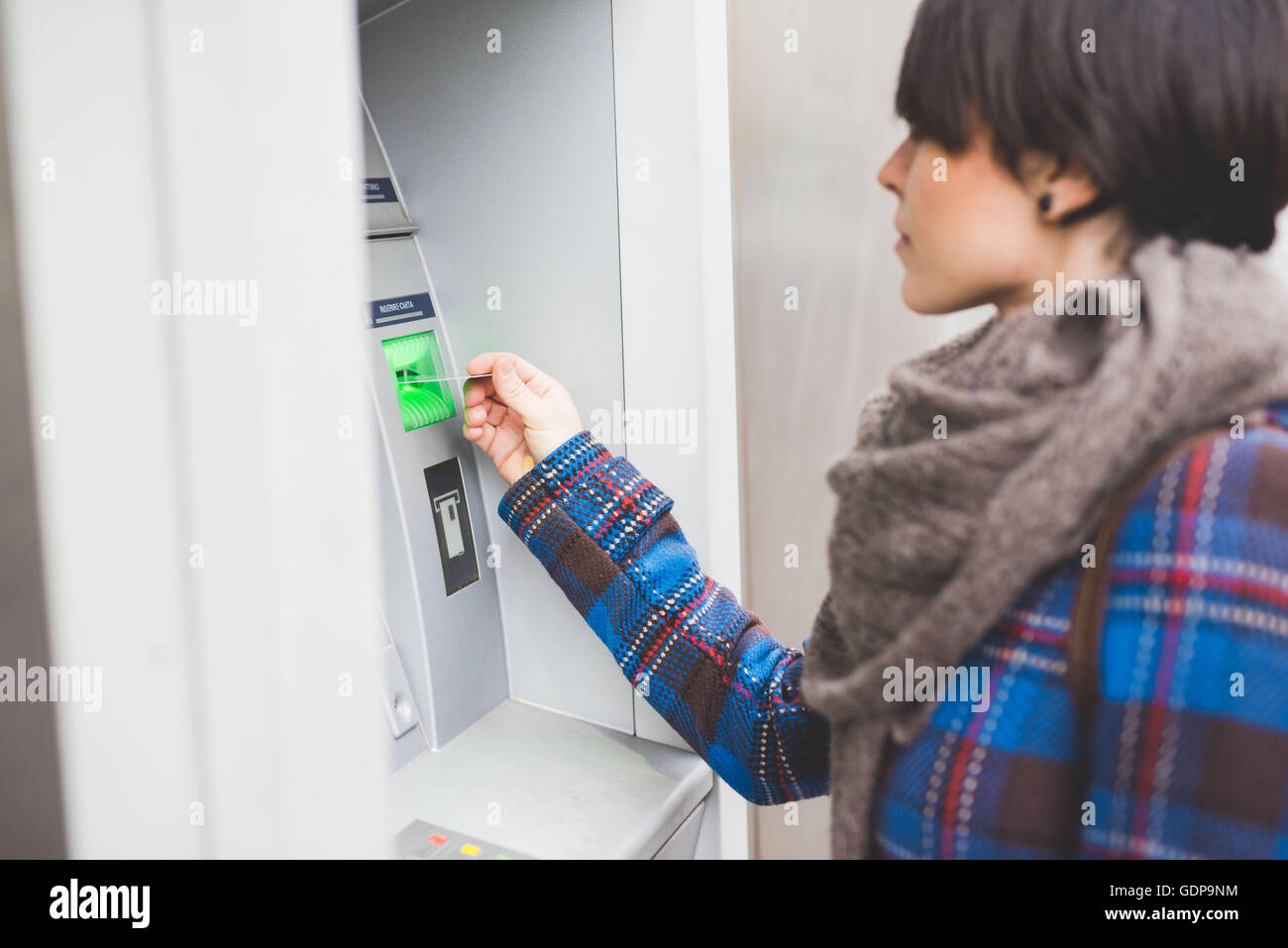 Young woman using cash machine, rear view Stock Photo - Alamy