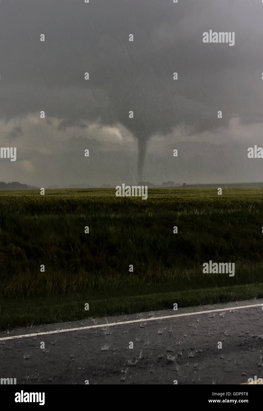 A nearly rain-wrapped tornado touches down near a farm in Kansas, hail ...