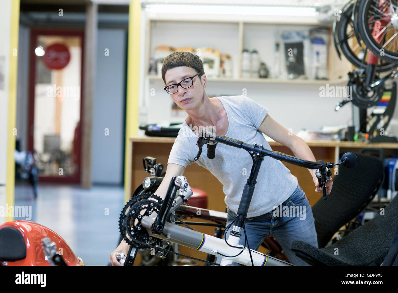 Woman in bicycle workshop checking pedal on recumbent bicycle Stock ...