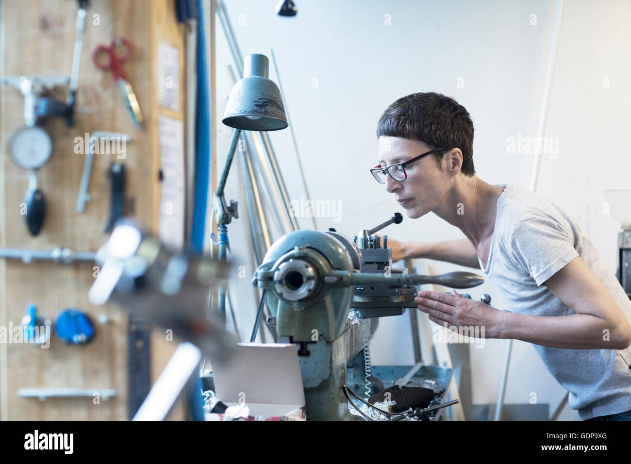 Woman in workshop using machine Stock Photo - Alamy