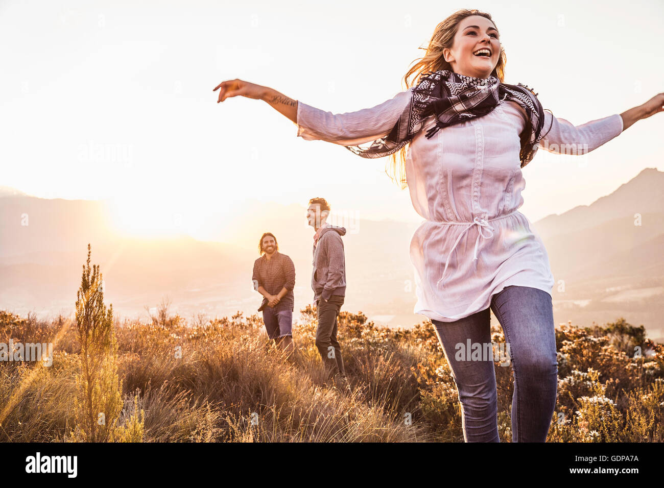 Woman with friends on grassland, running with arms open Stock Photo - Alamy