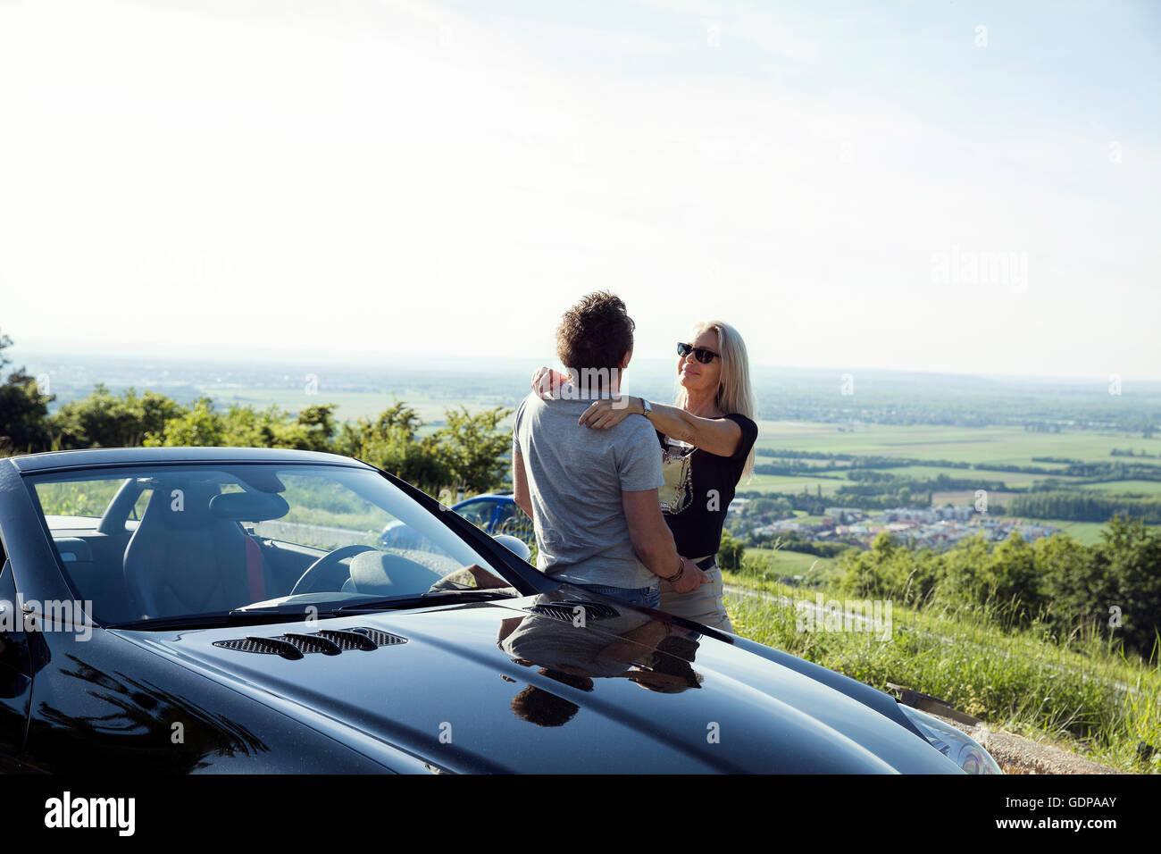 Mature couple hugging by convertible car Stock Photo - Alamy