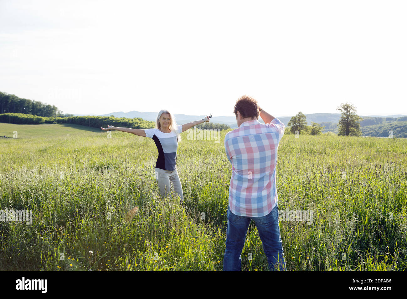 Man photographing woman in field Stock Photo - Alamy