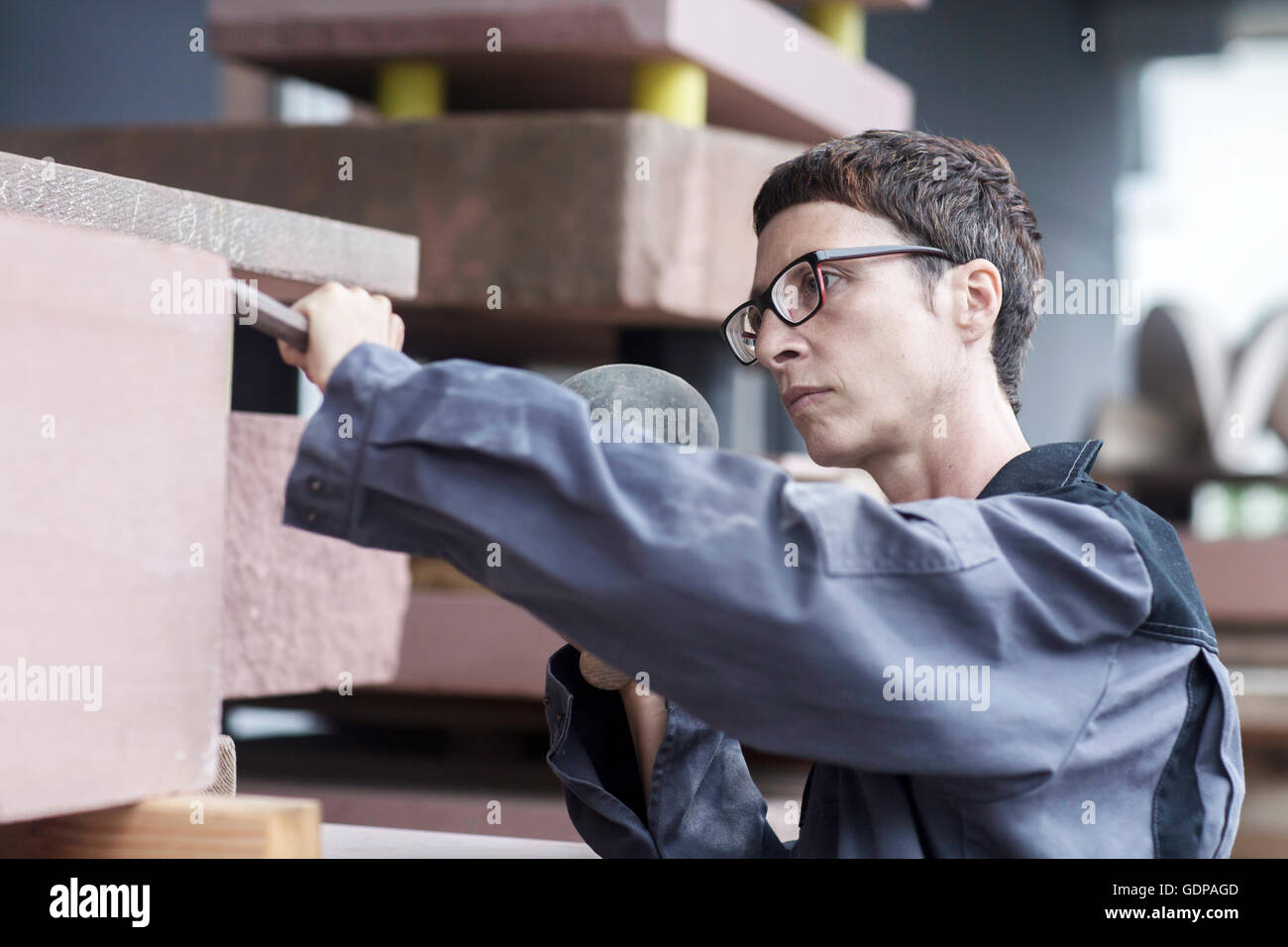 Stonemason using chisel and mallet on block of stone Stock Photo - Alamy