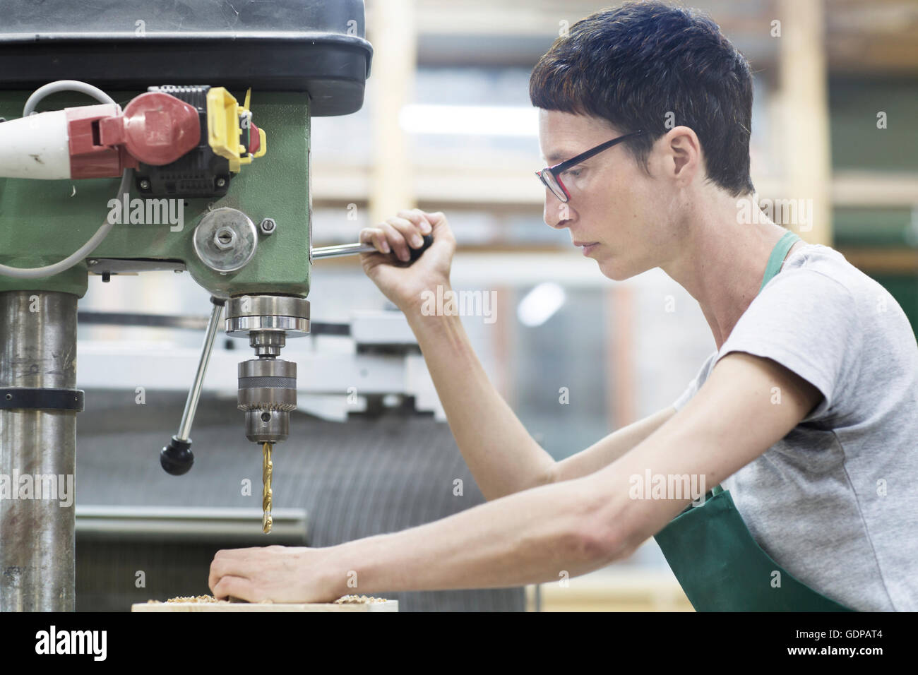 Woman in workshop using drilling machinery Stock Photo - Alamy