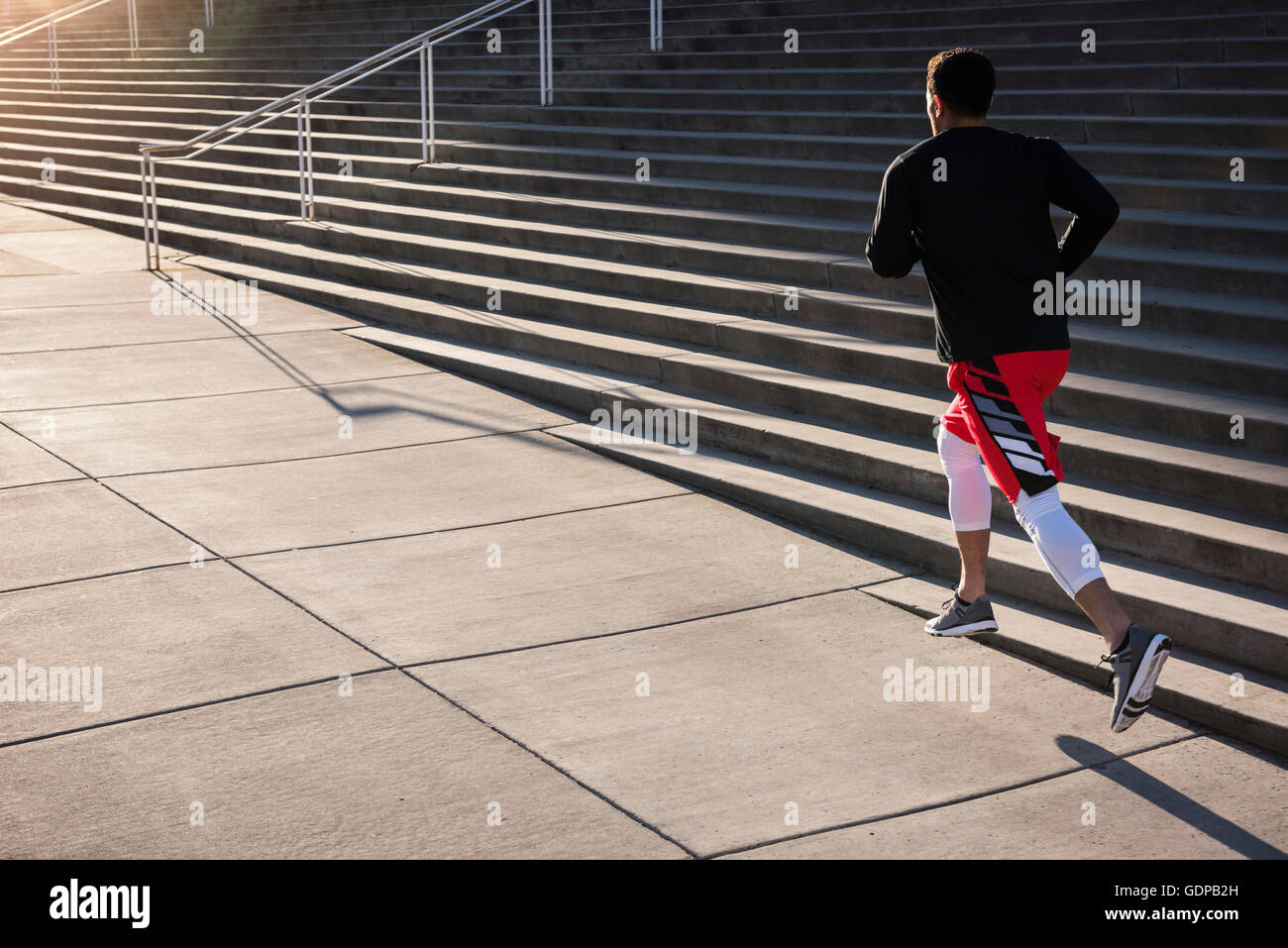 Young male runner running past city stairway Stock Photo - Alamy