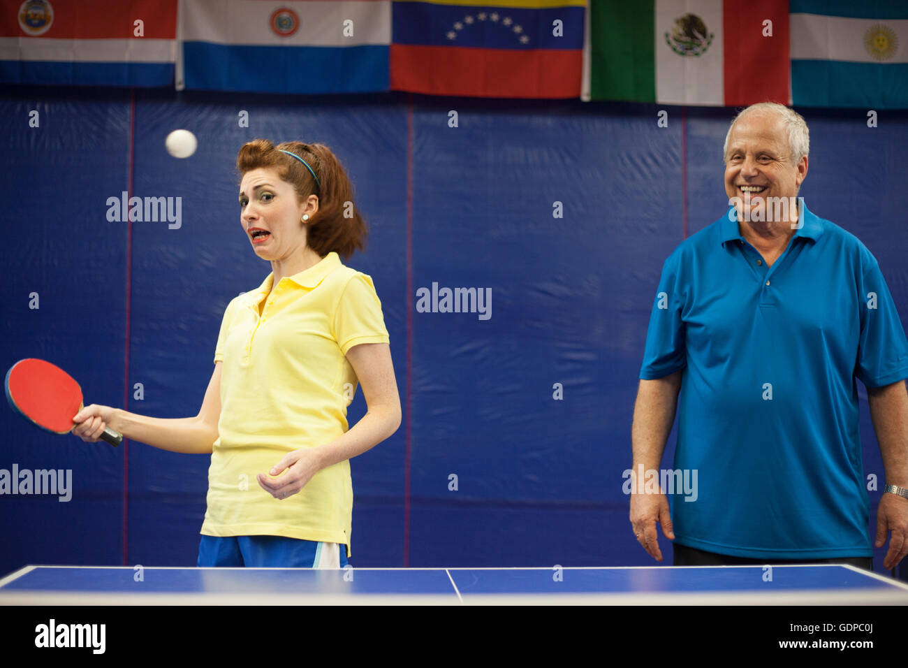 Table tennis coach laughing at student playing Stock Photo - Alamy