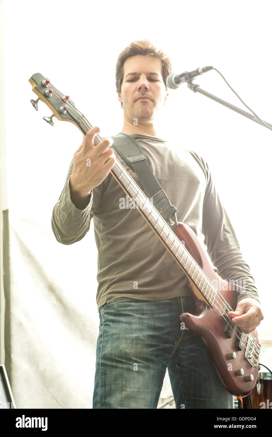 A Rock musician playing passionately bass in the rehearsal Studio Stock ...