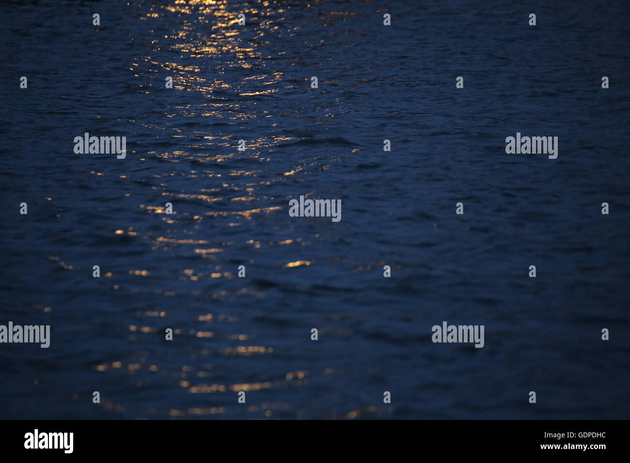 Reflections of yellow light on water in the night Stock Photo - Alamy