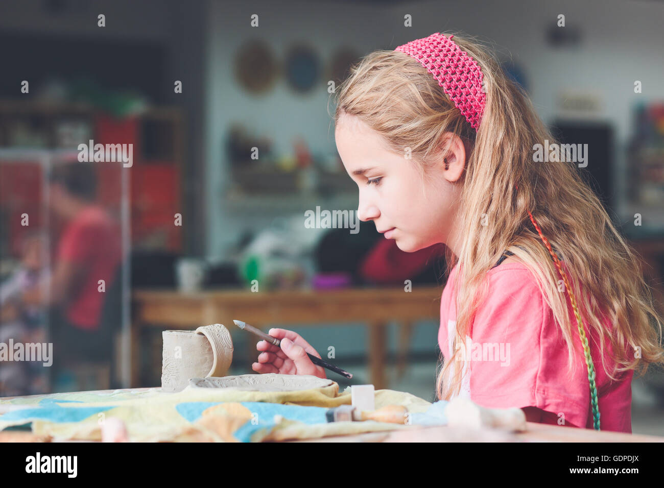 Girl making her first pottery in ceramic workshop Stock Photo - Alamy