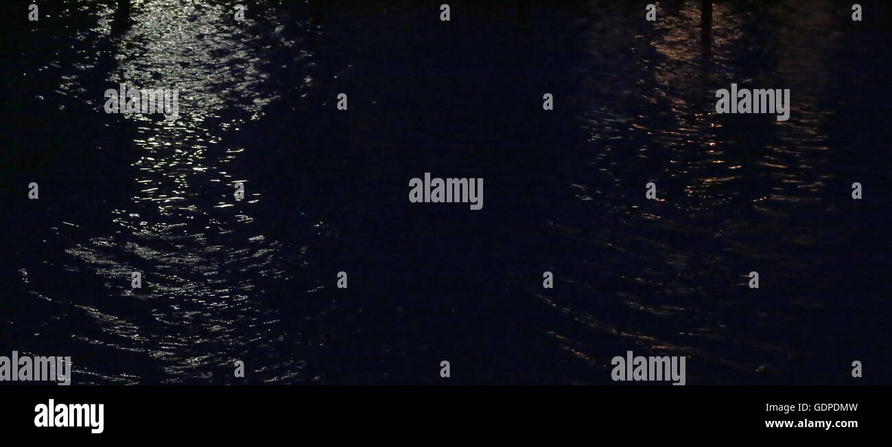 Reflections of yellow and white light on water in the night Stock Photo ...