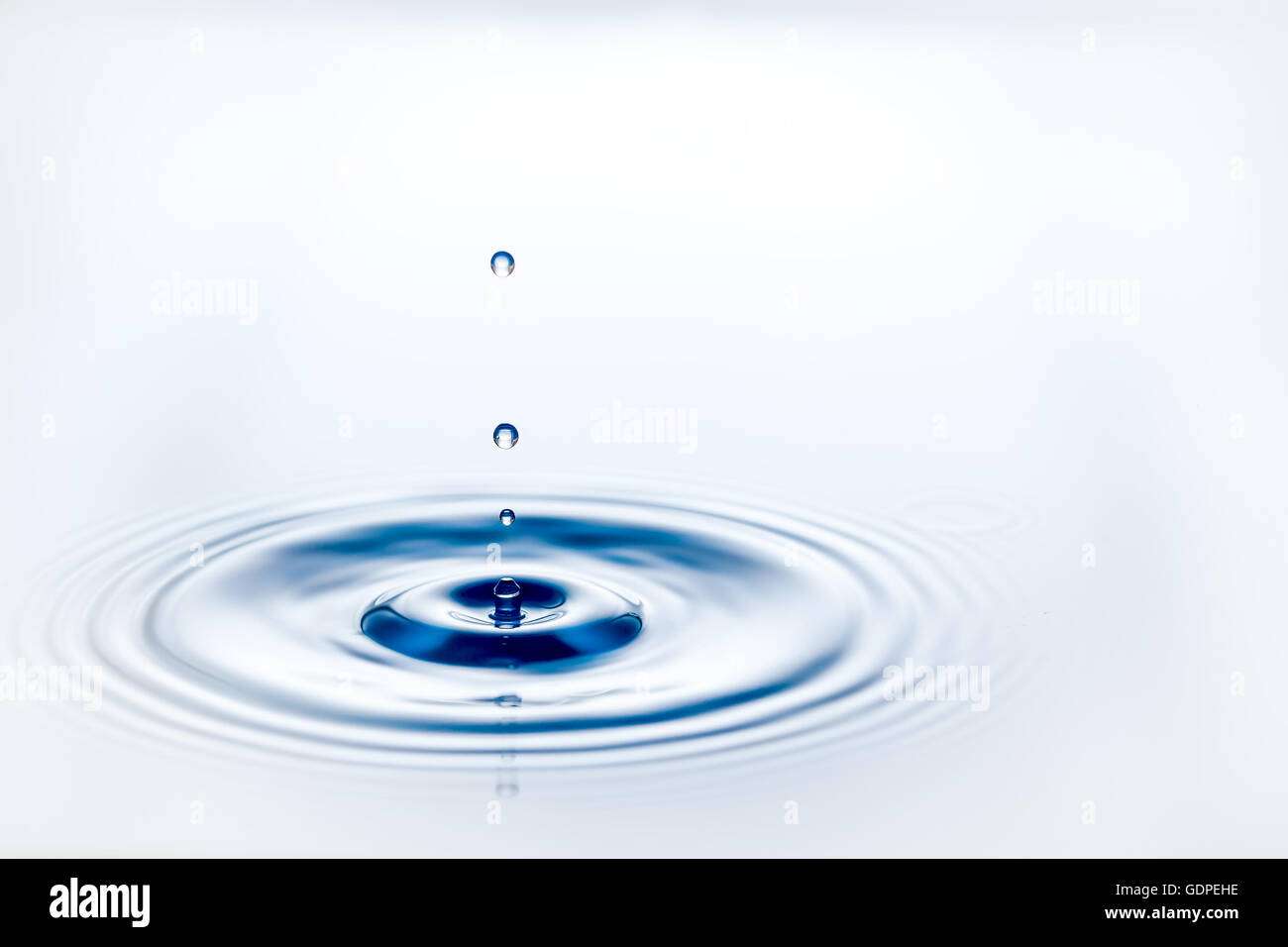 Drop of water falling on water level Stock Photo - Alamy