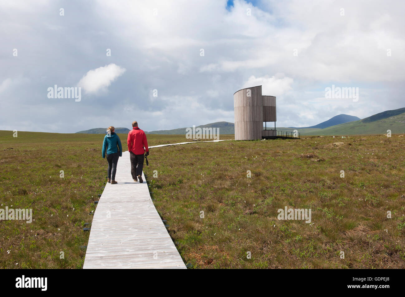 Visitors walking towards the viewing tower at Forsinard RSPB reserve ...