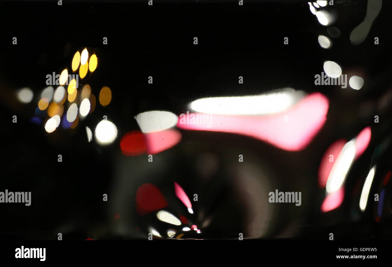 Distorted reflections of lights in the night on a fun house mirror ...