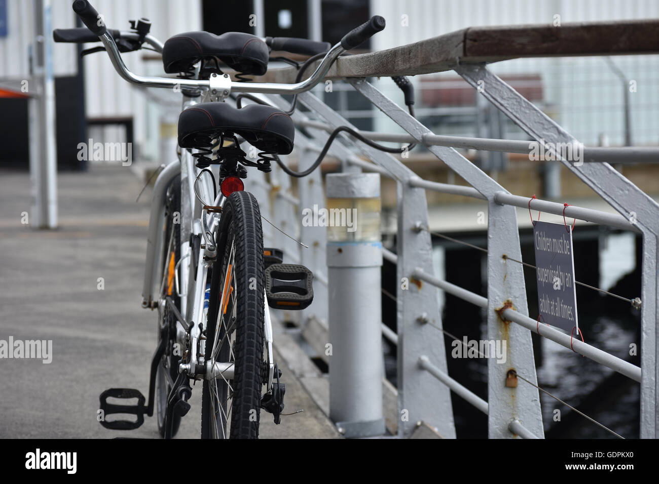Tandem bicycle chained to railing Stock Photo - Alamy