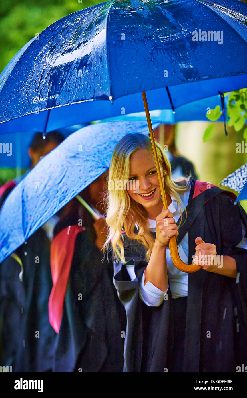 Young woman, walking in the rain, after graduating in at a Cambridge ...