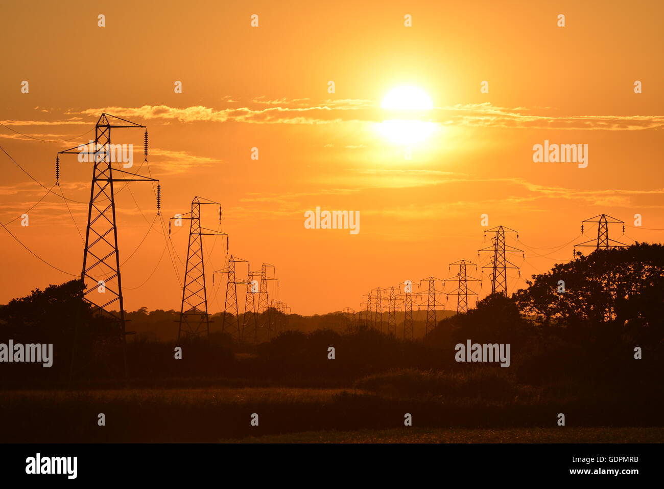 Sun setting behind electricity power lines Stock Photo - Alamy
