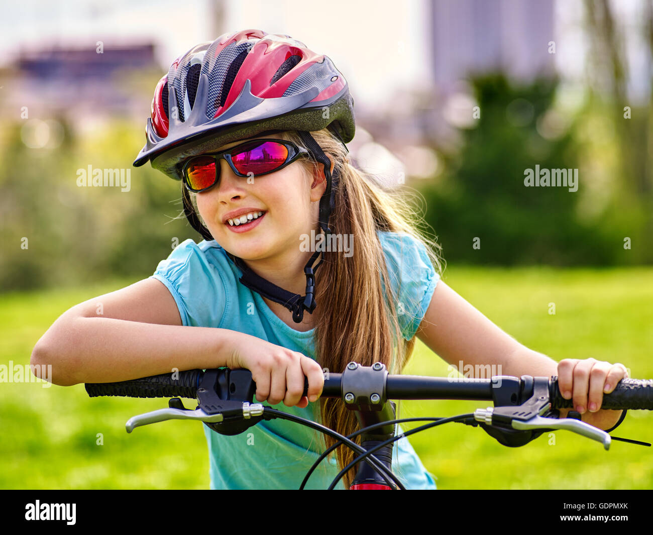 Girl rides on bicycle green grass in park outdoor Stock Photo - Alamy