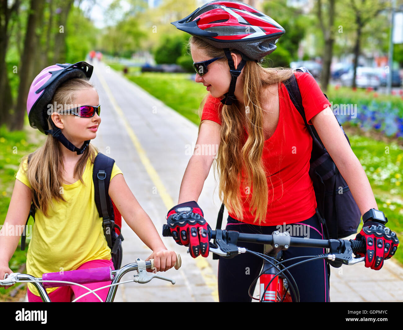 Girls children cycling on yellow bike lane Stock Photo - Alamy