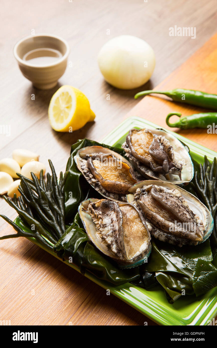 Fresh Uncooked Abalone with Seaweed on Green Square Plate with Other ...