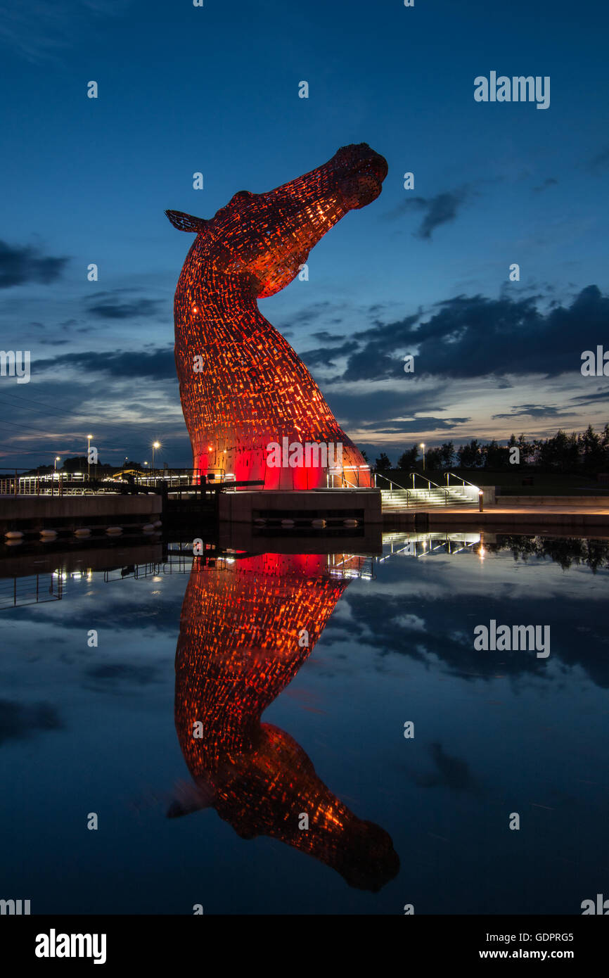 One of the Kelpies horse sculptures reflecting in water in Helix park ...