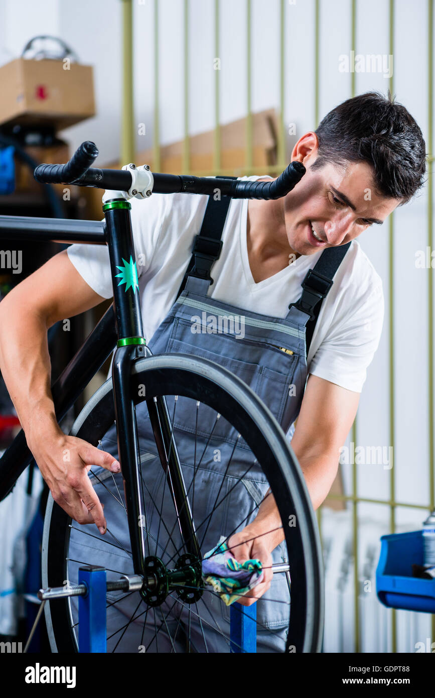 Mechanic repairing bicycle workshop hi-res stock photography and images ...