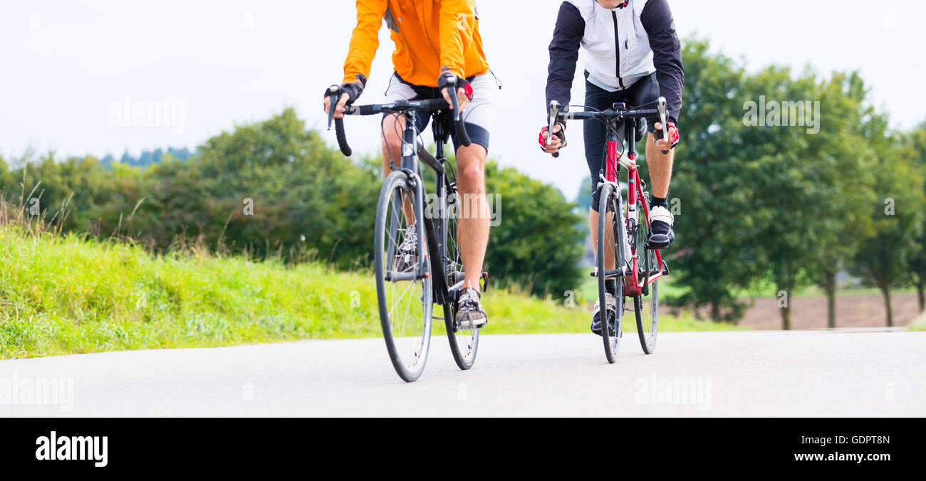 Two bicyclists doing sport with their bikes having a sport race, crop ...
