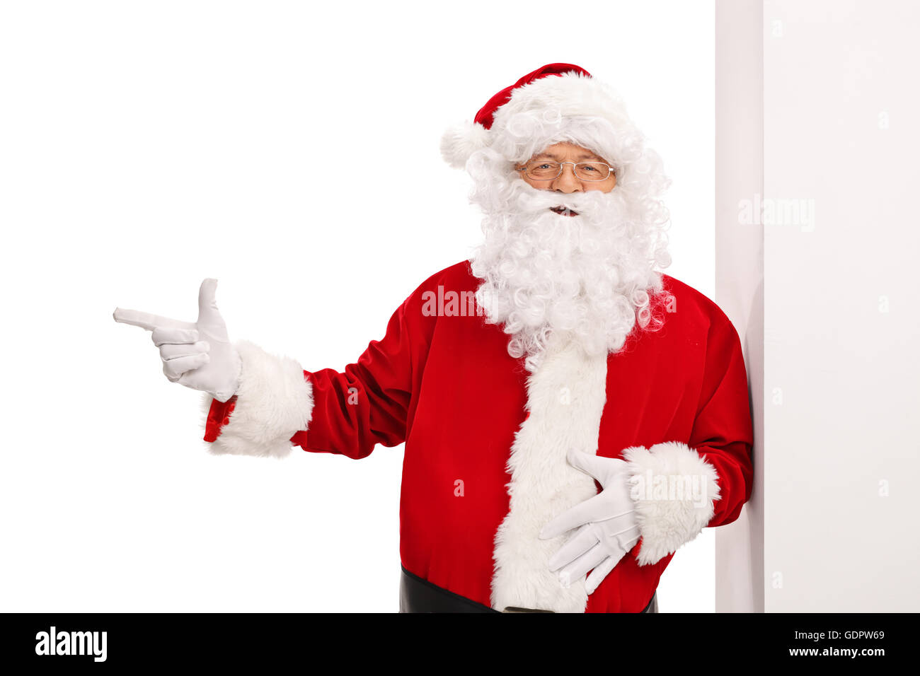 Santa Claus leaning against a wall and pointing with his finger to the ...