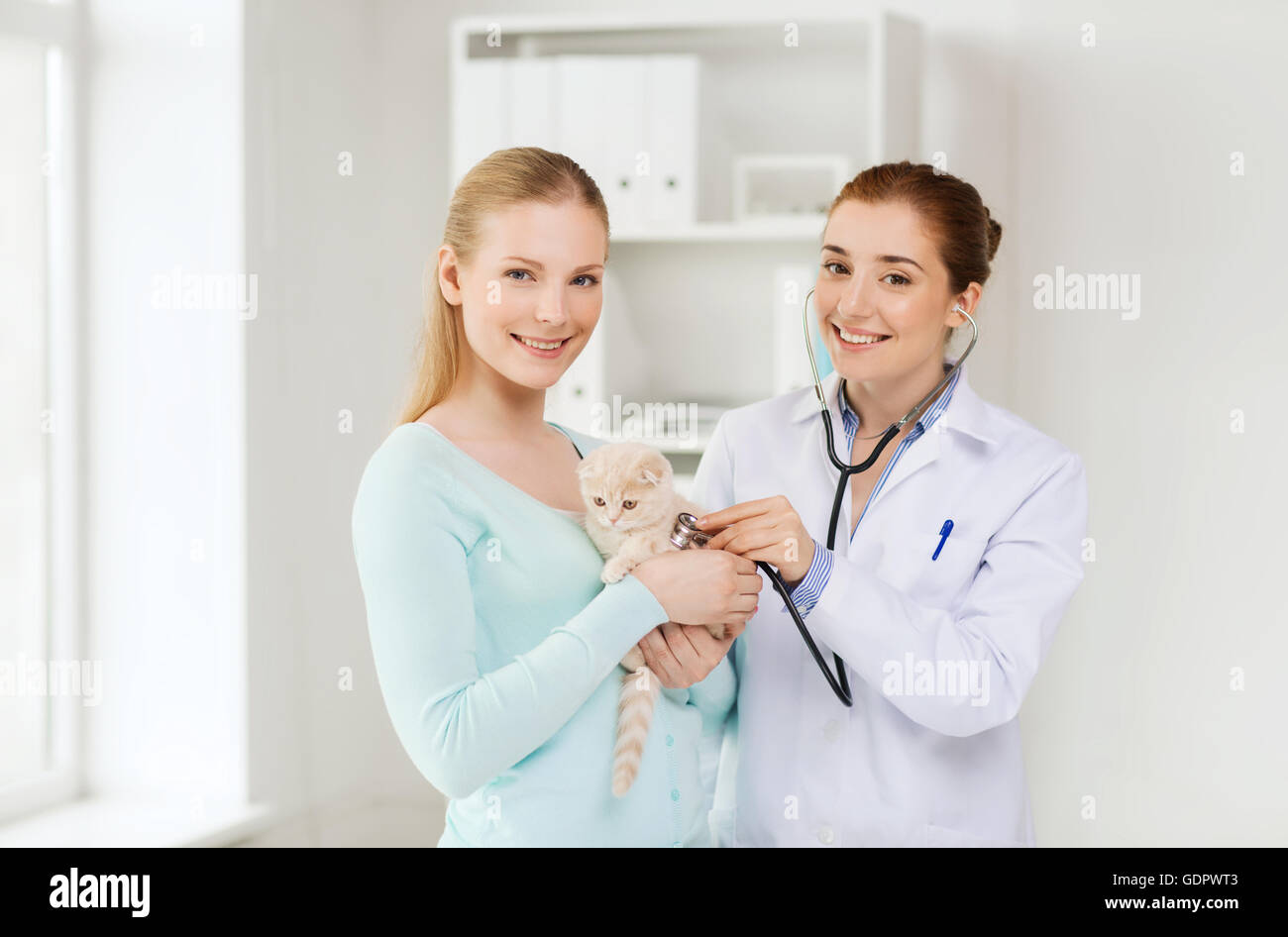 happy woman with cat and doctor at vet clinic Stock Photo - Alamy