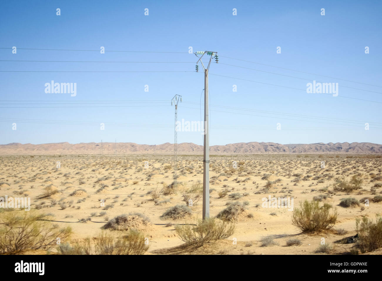 Power lines in rocky desert at the beginning of Sahara in the middle of ...