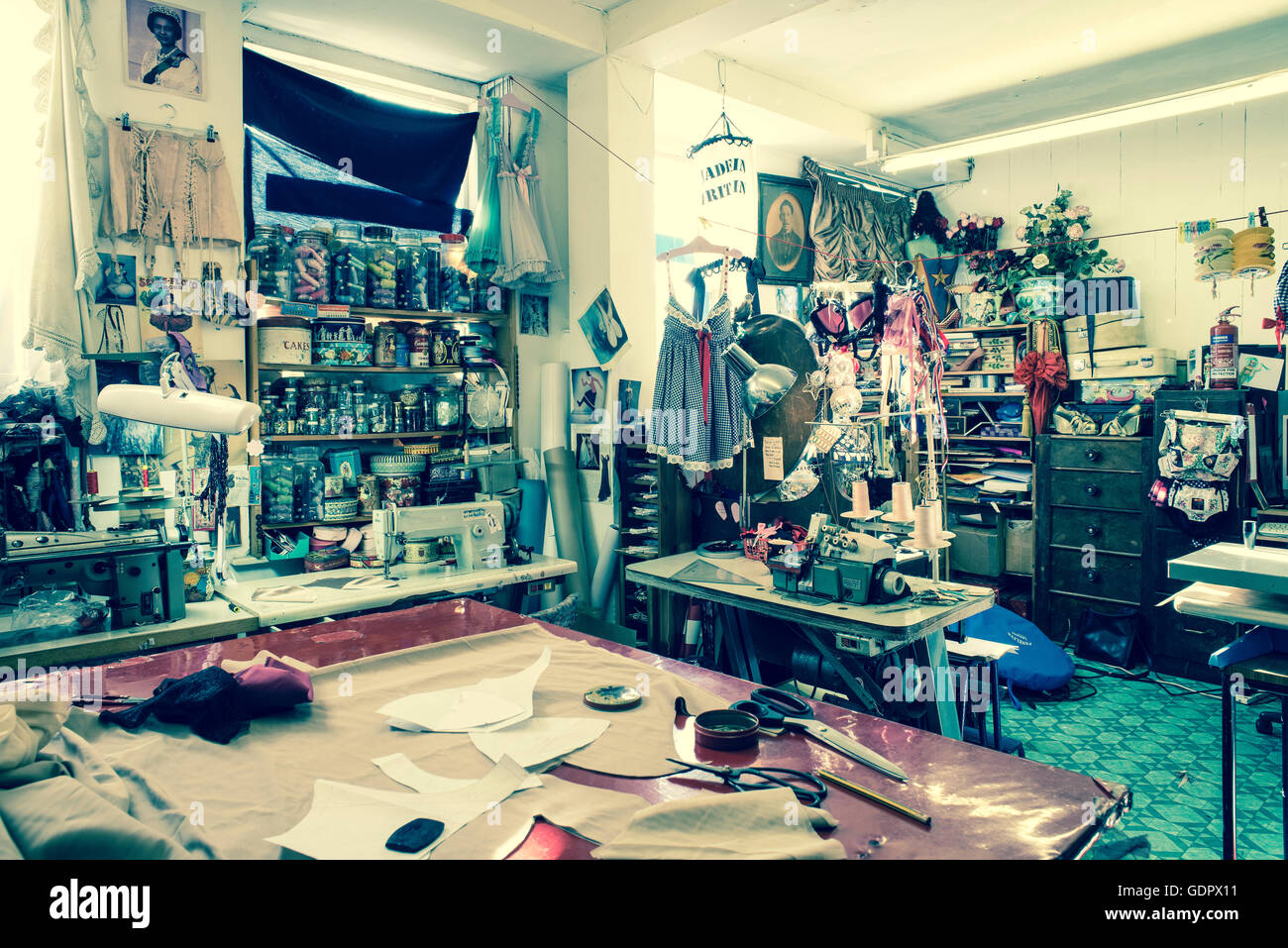 An inside view of a dressmaker's shop with a large cutting table in the ...