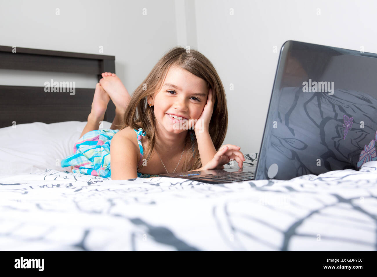 nine years old child having fun using laptop at her bedroom Stock Photo ...