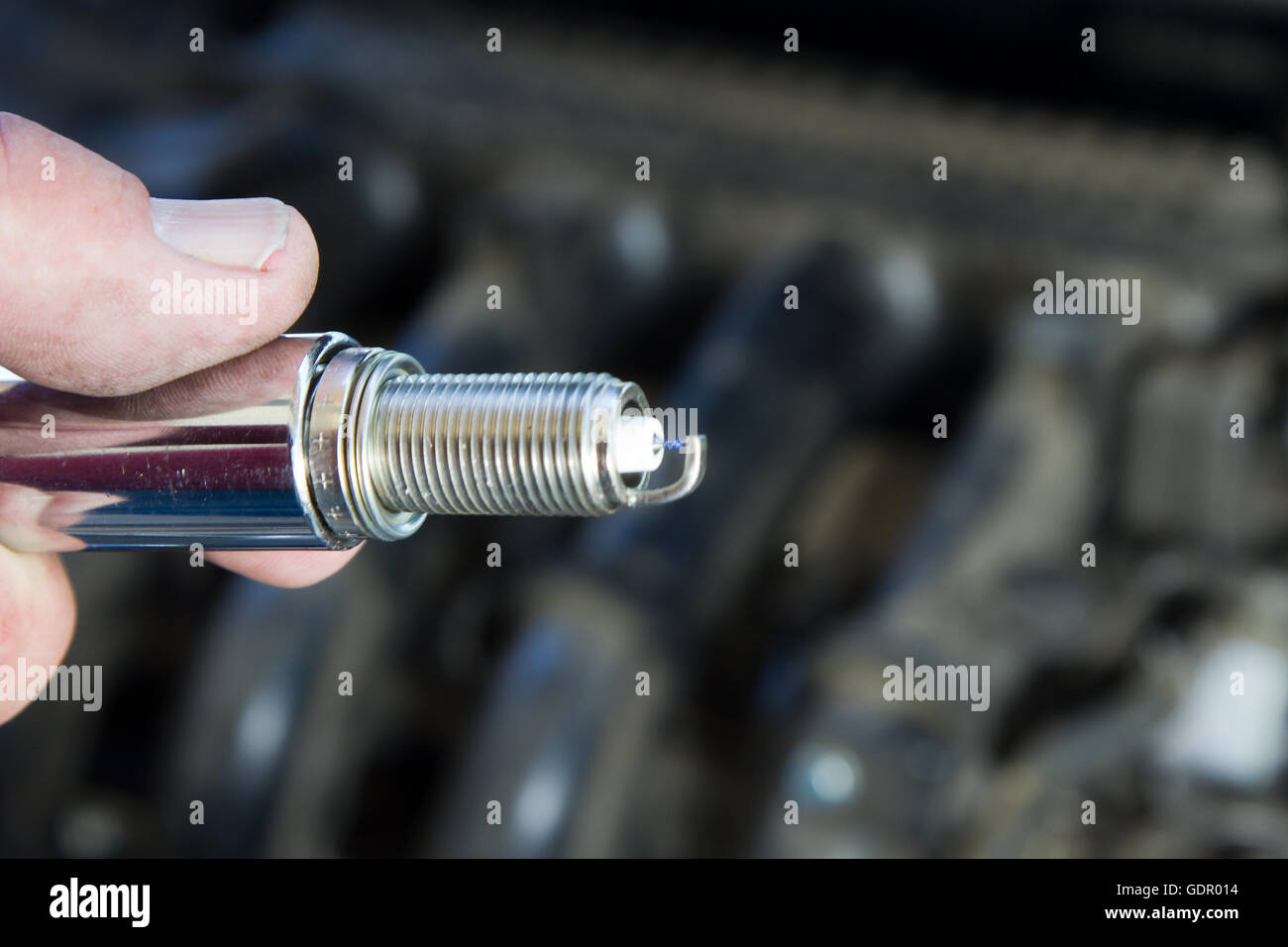 A mechanic inspecting a new spark plug Stock Photo - Alamy