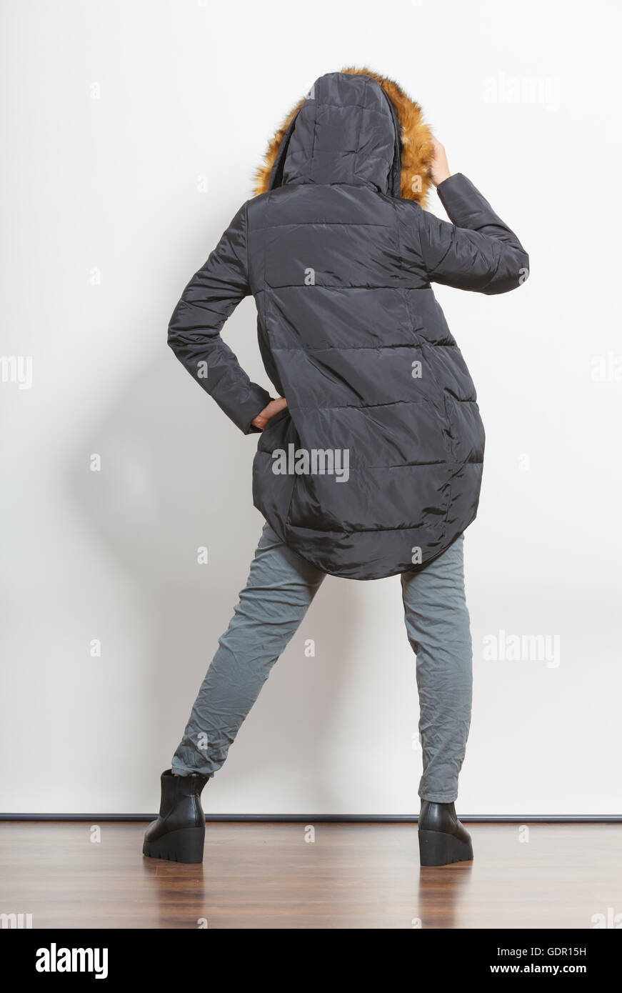 Back view of young fashionable girl wearing jacket with hood. Fashion ...