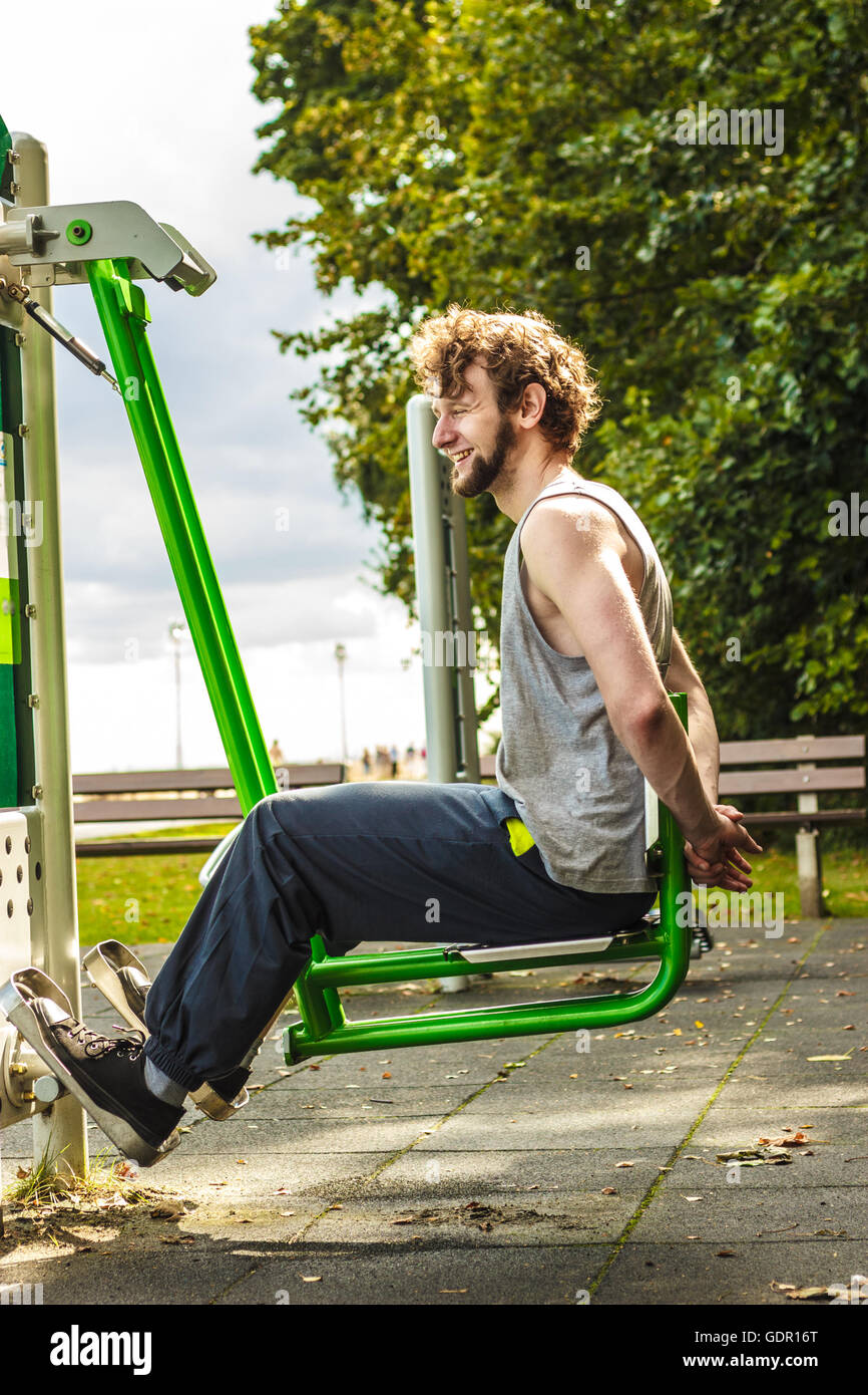 Active young man exercising on leg press machine. Muscular strong guy ...