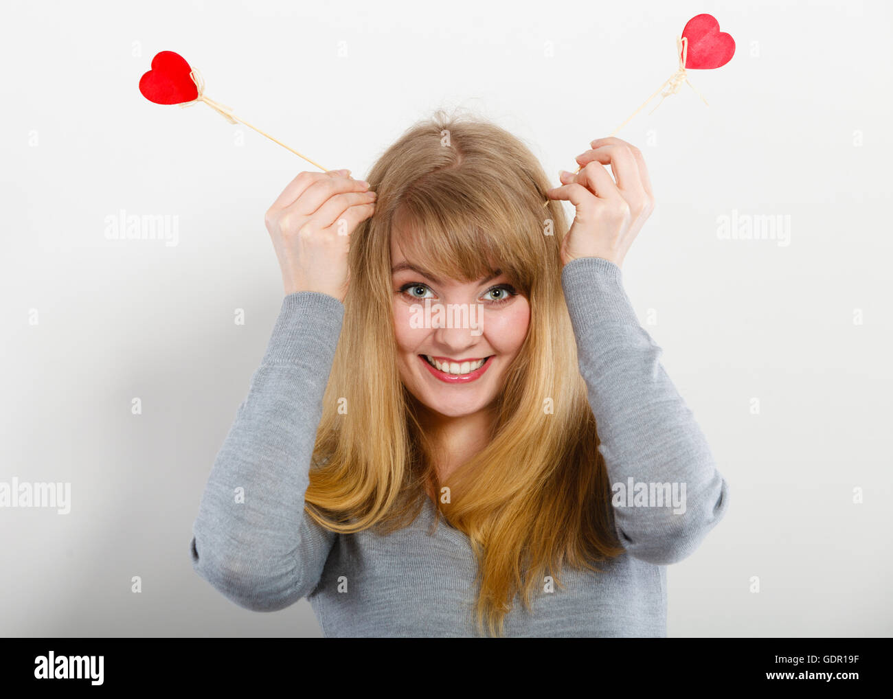 Love and fun concept. Lovely enjoyable smiling woman playing with two ...