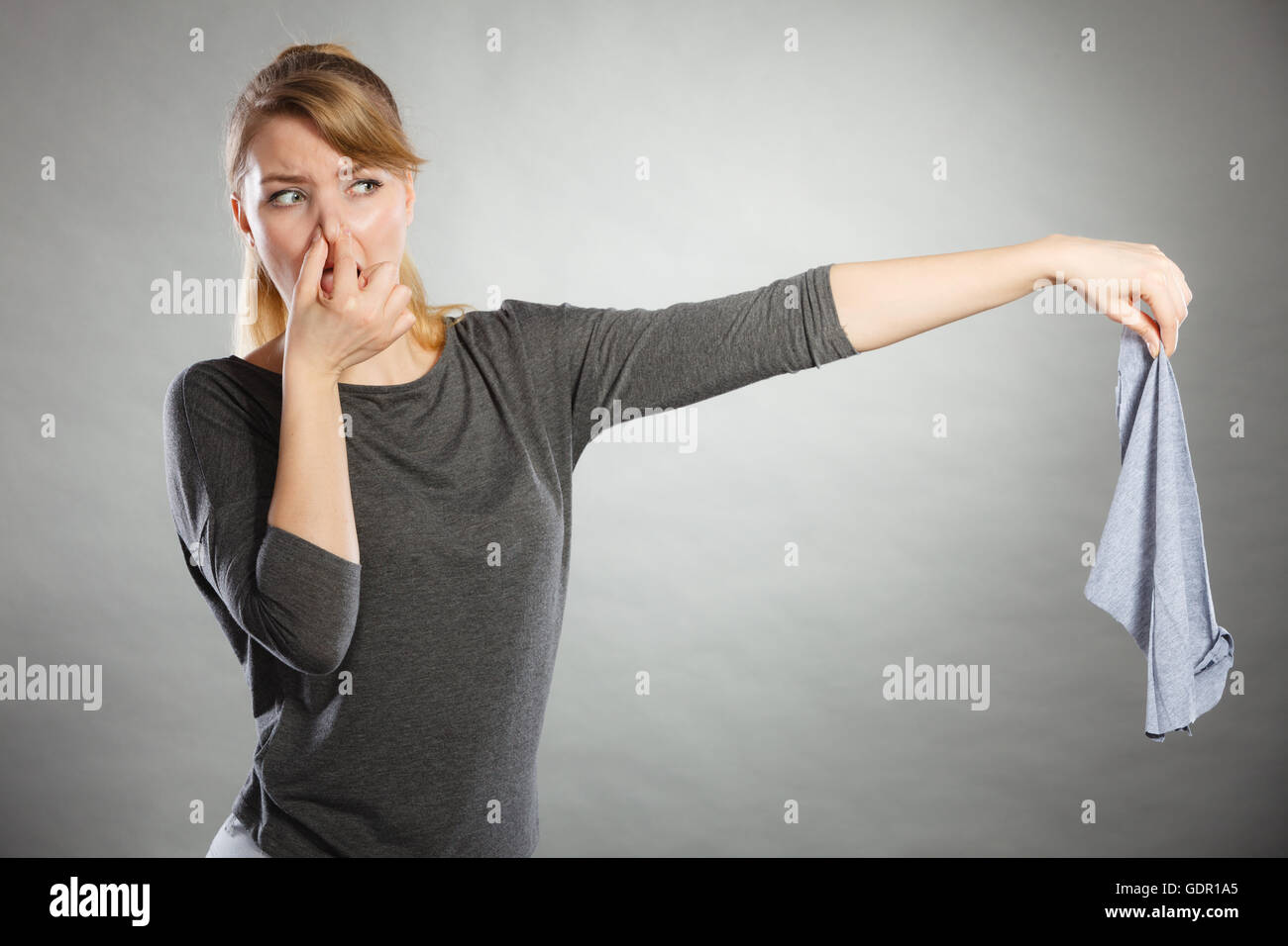 Household duties concept. Young disgust girl holding cleaning cloth rag ...