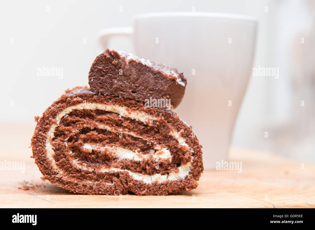 Slice of chocolate cake viewed from the side, in profile with a mug of ...