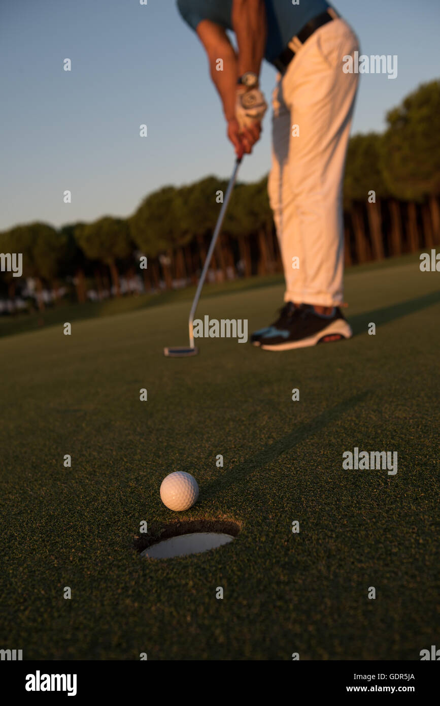 golfer hitting ball shot with driver on golf course at beautiful sunset ...