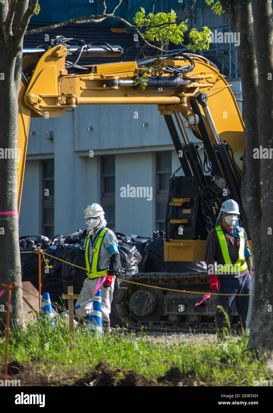 Workers remove top soil contaminated by nuclear radiations after the ...