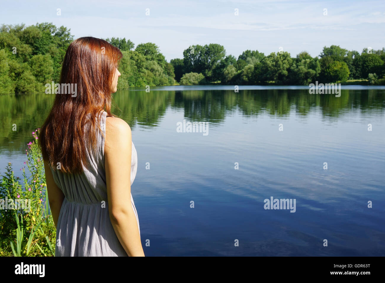 young woman overlooking idyllic lake Stock Photo - Alamy